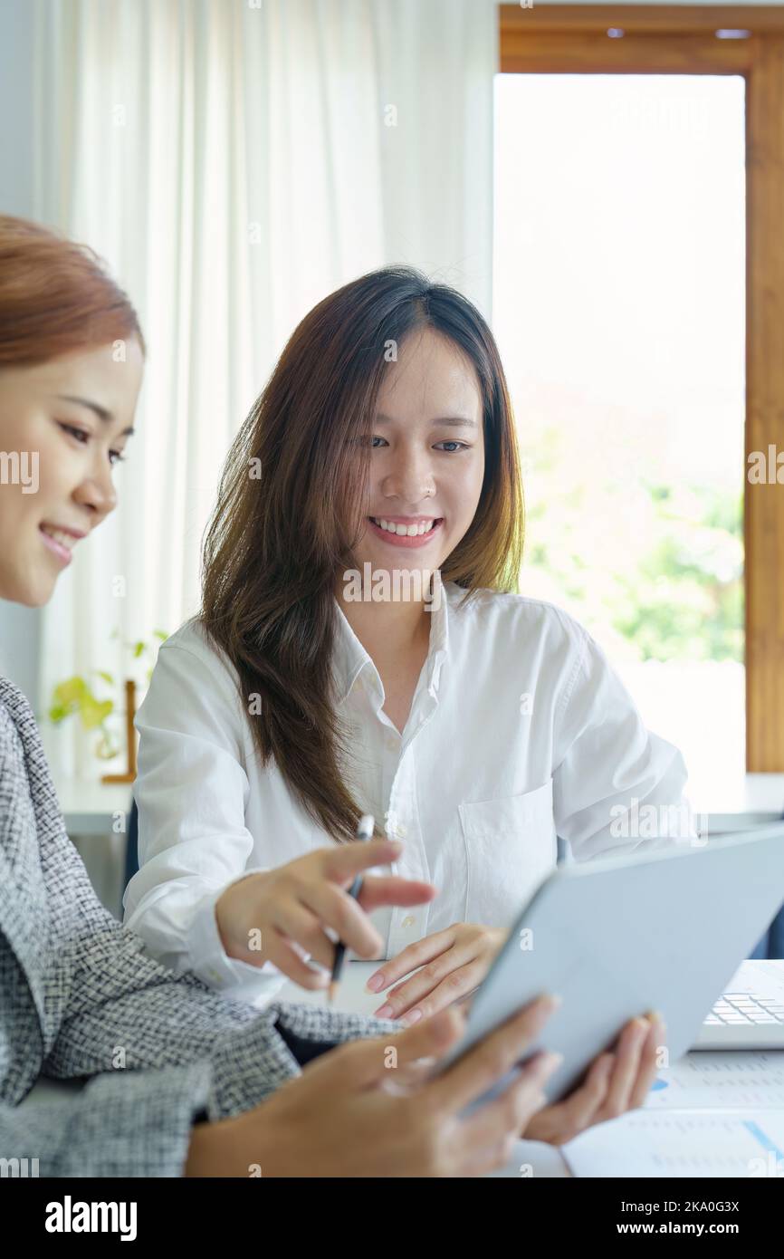 Portrait of a young Asian businesswoman using tablet computers to plan ...