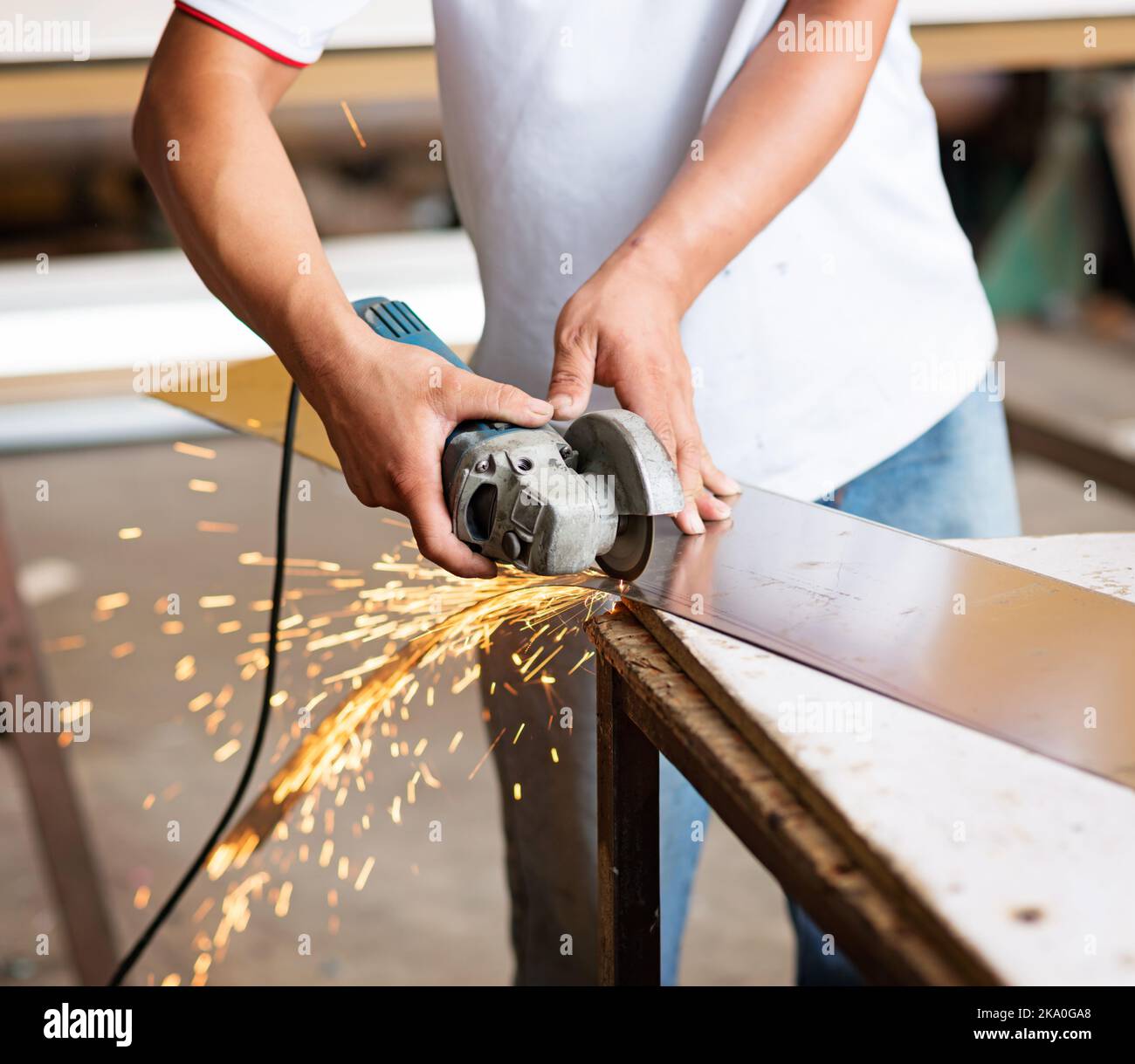A construction worker using an angle grinder producing a lot of sparks ...