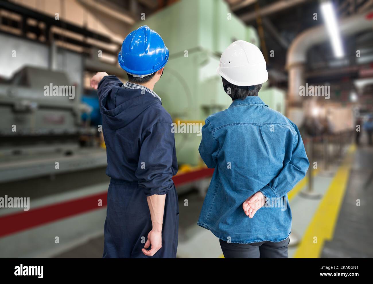 A team of construction workers with helmets at work place in a factory ...