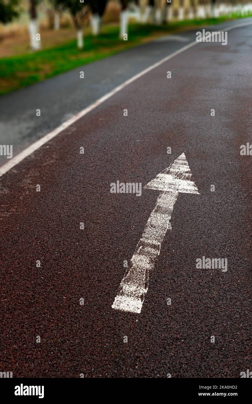 White arrow symbol on the ground Stock Photo - Alamy