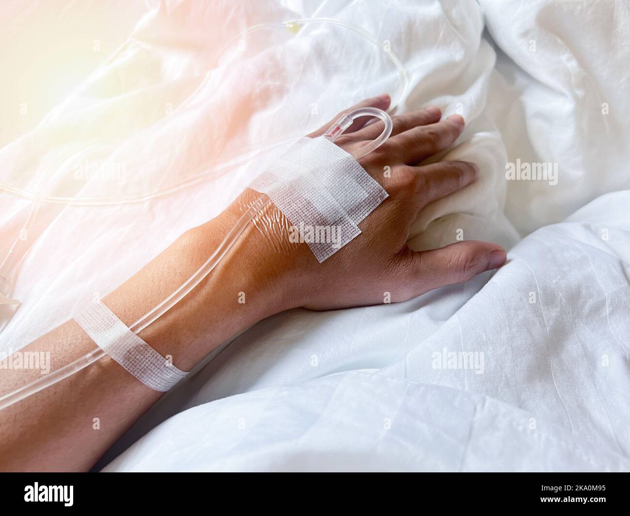 patient on hospital bed with blurry of Saline intravenous (iv) drip on ...
