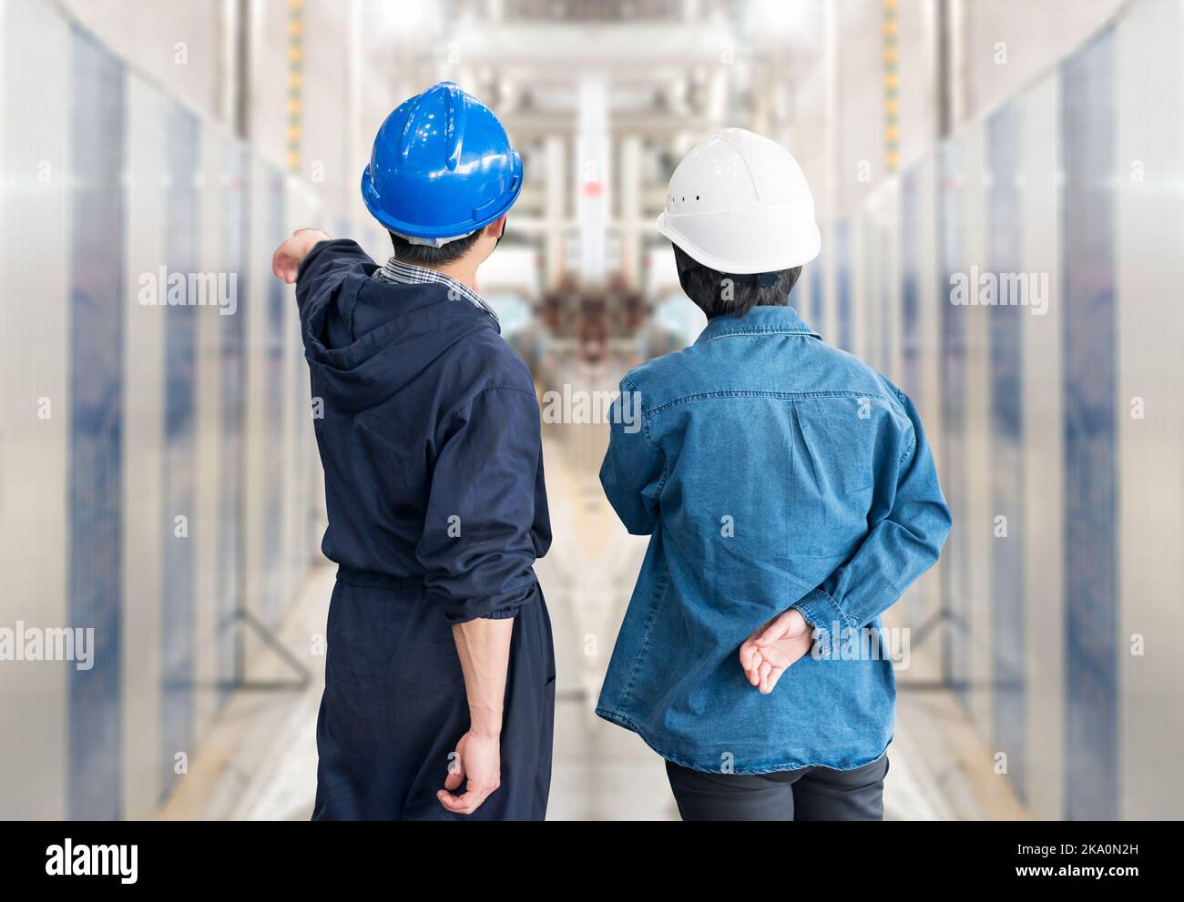 A team of construction workers with helmets at work place in a factory ...