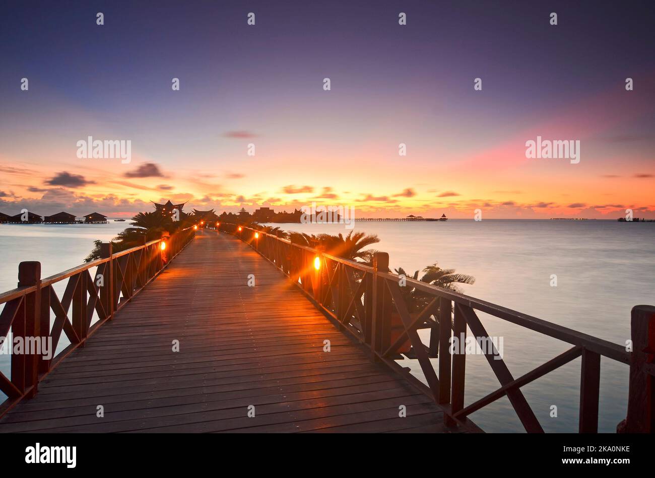 Long bridge heading to beautiful resort at Mabul Island during sunset ...