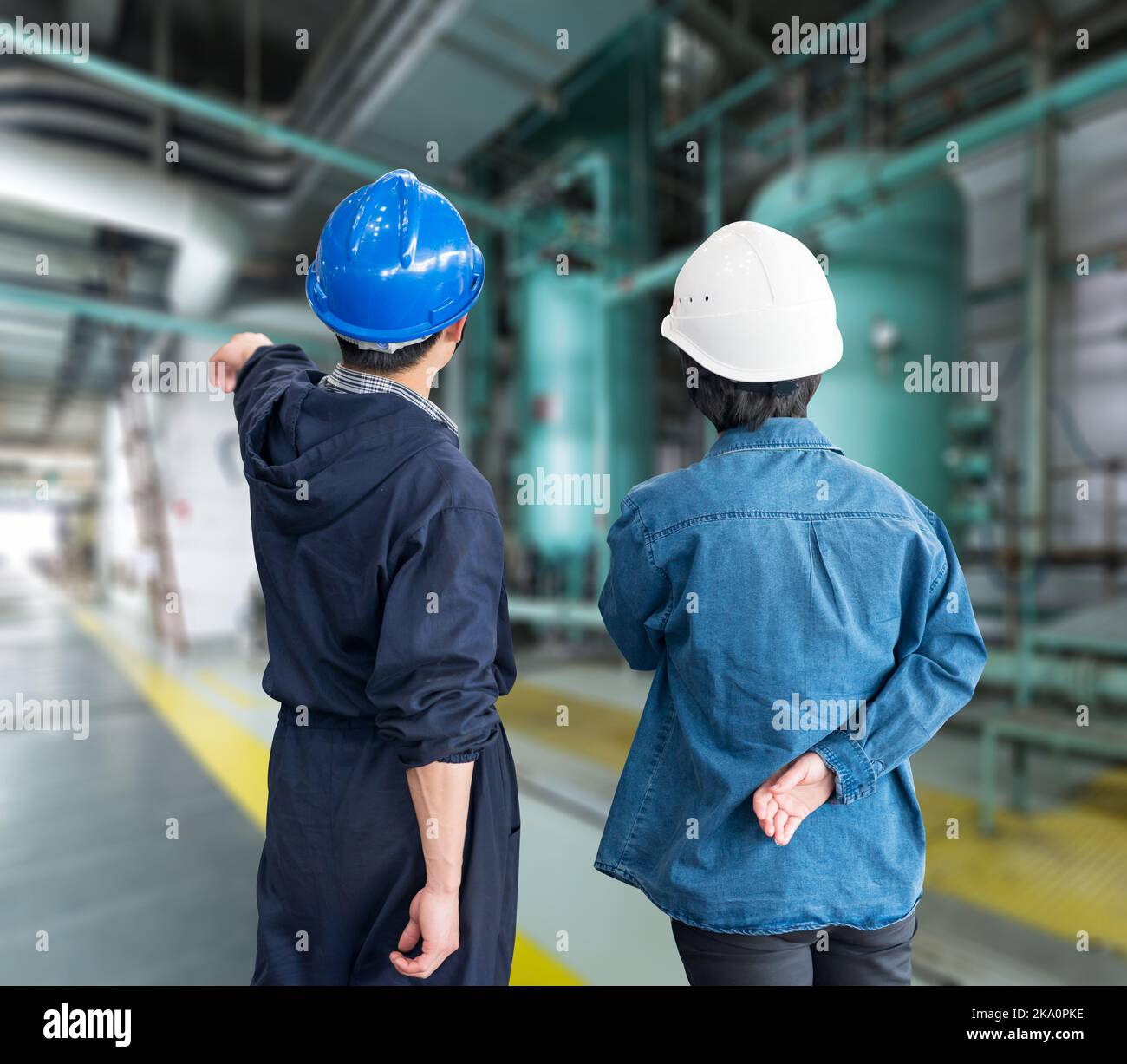 A team of construction workers with helmets at work place in a factory ...