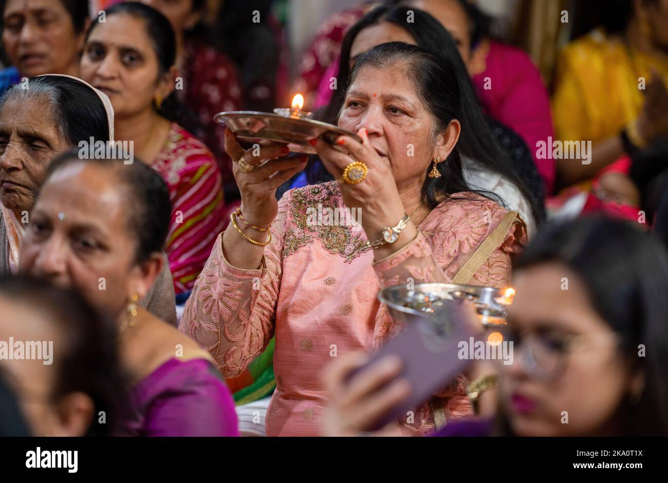 A woman holds lit lamp during a Diwali celebration. Diwali is the five ...