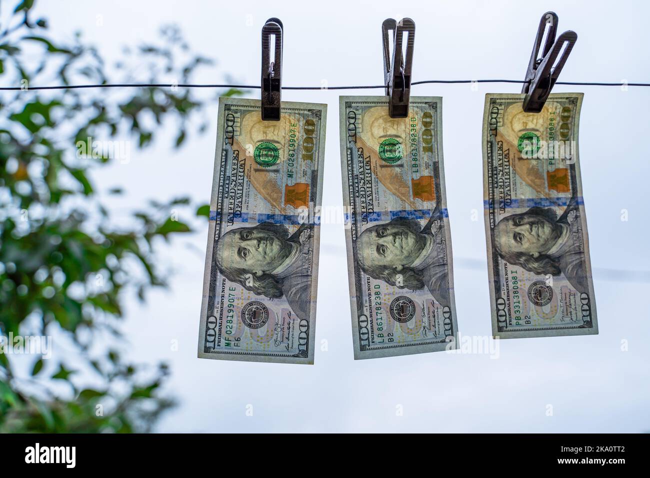 One hundred US dollar bills hanging pinned with clothespins close-up ...