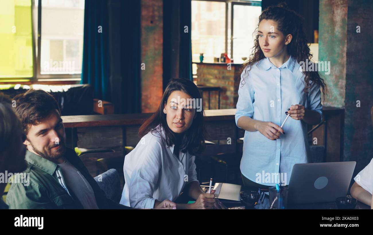 Confident young woman executive director is talking to multi-ethnic ...