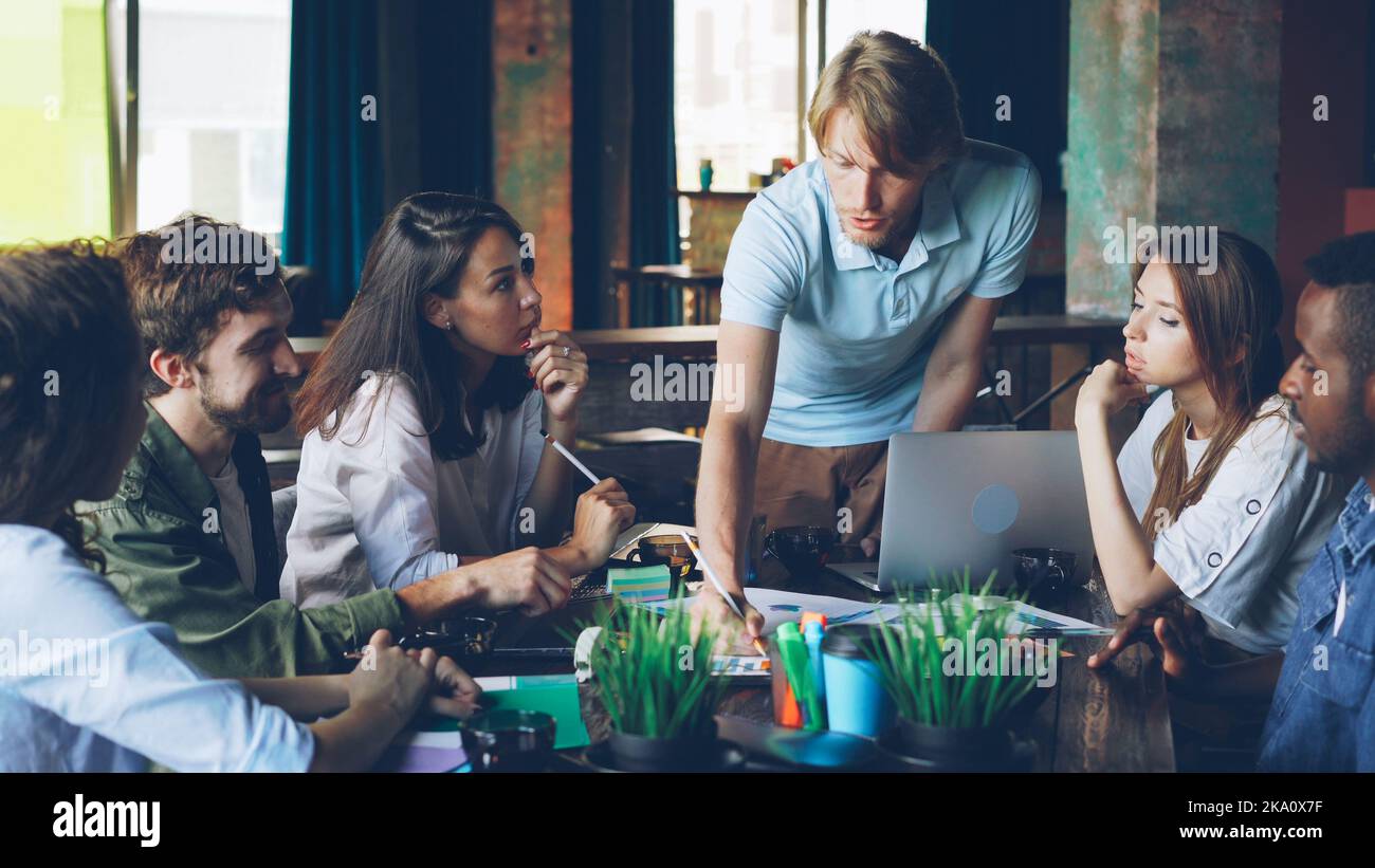 Multiracial group of professionals creative team is discussing charts ...