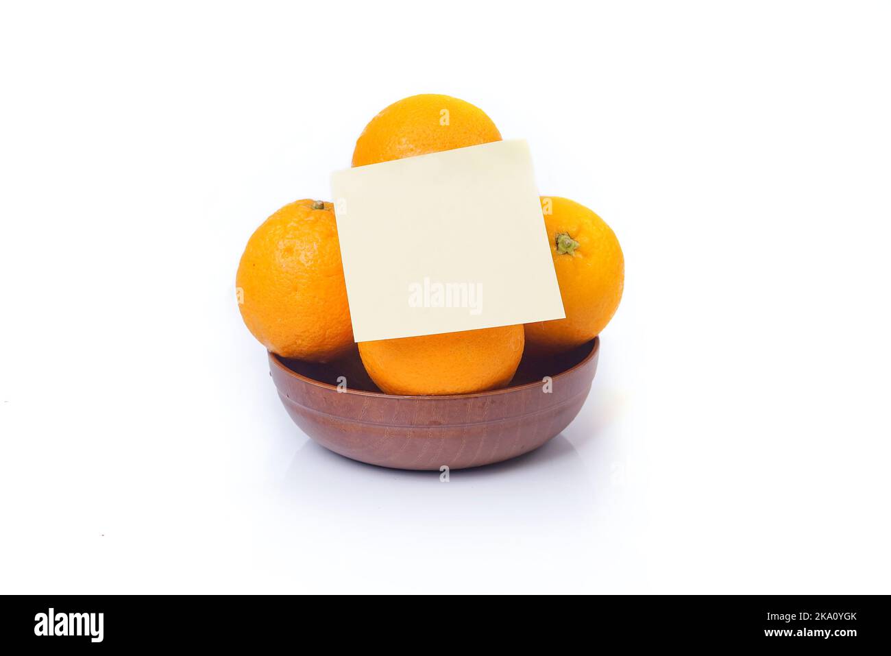 Basket of oranges isolated on white background with yellow sticky note ...