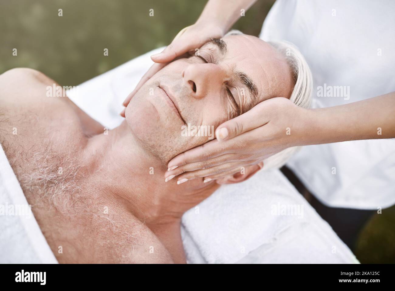 Magic Hands A Relaxed Middle Aged Man Lying On His Back While Receiving A Massage At A Spa