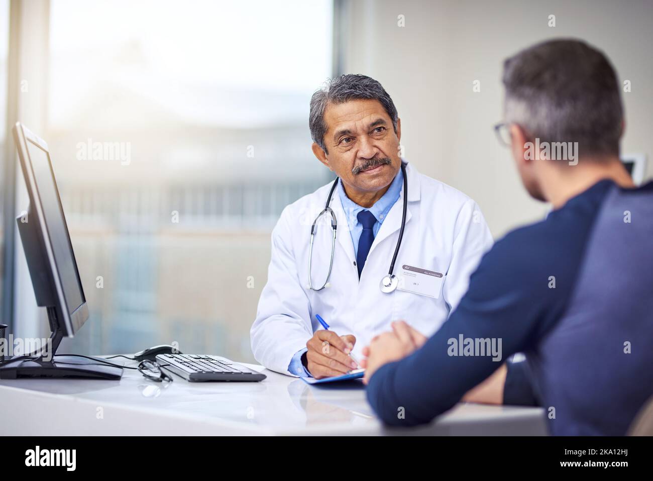 You have a doctor who cares. a cheerful mature male doctor seated at ...