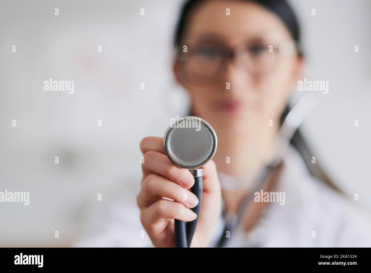 Let me take a listen. a young female doctor reaching out with a ...