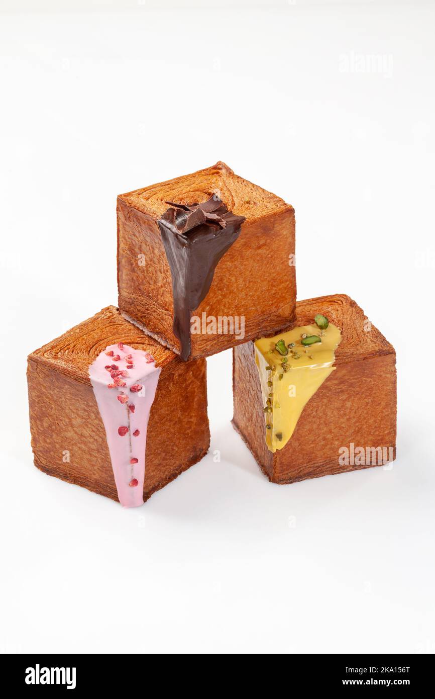 Pyramid of three sweet cubic croissants with berry sauce, pistachio ...