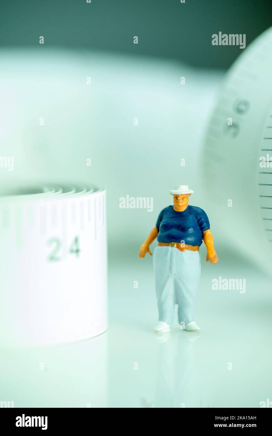 miniature figure of an obese man against measuring tape Stock Photo - Alamy