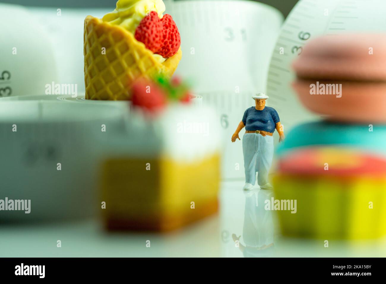 miniature figure of an obese man against measuring tape and unhealthy ...