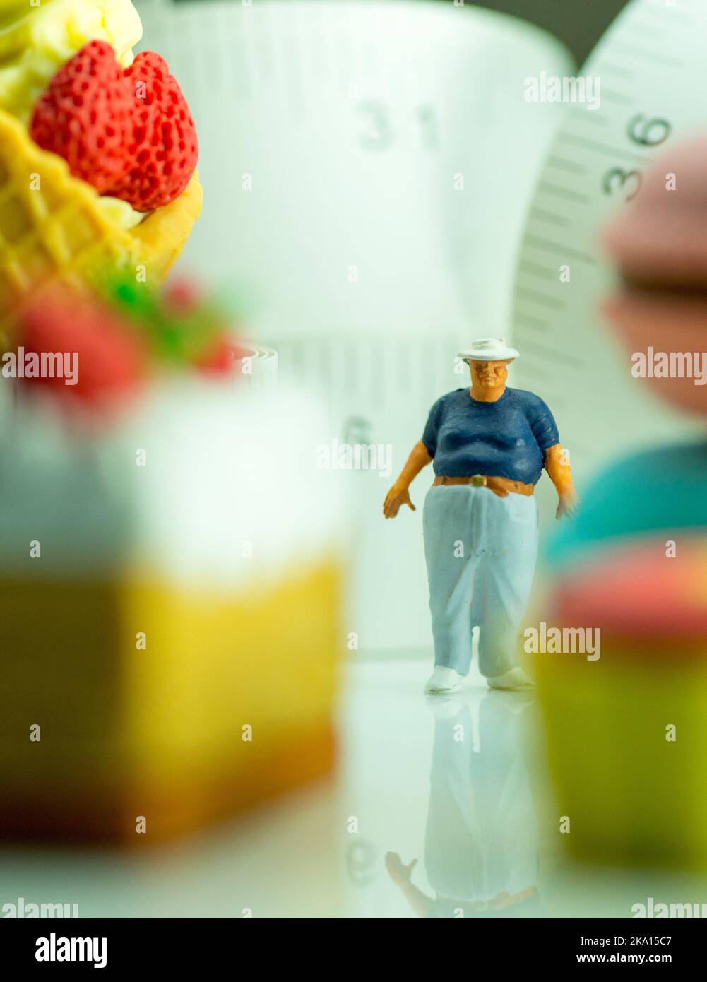 miniature figure of an obese man against measuring tape and unhealthy ...