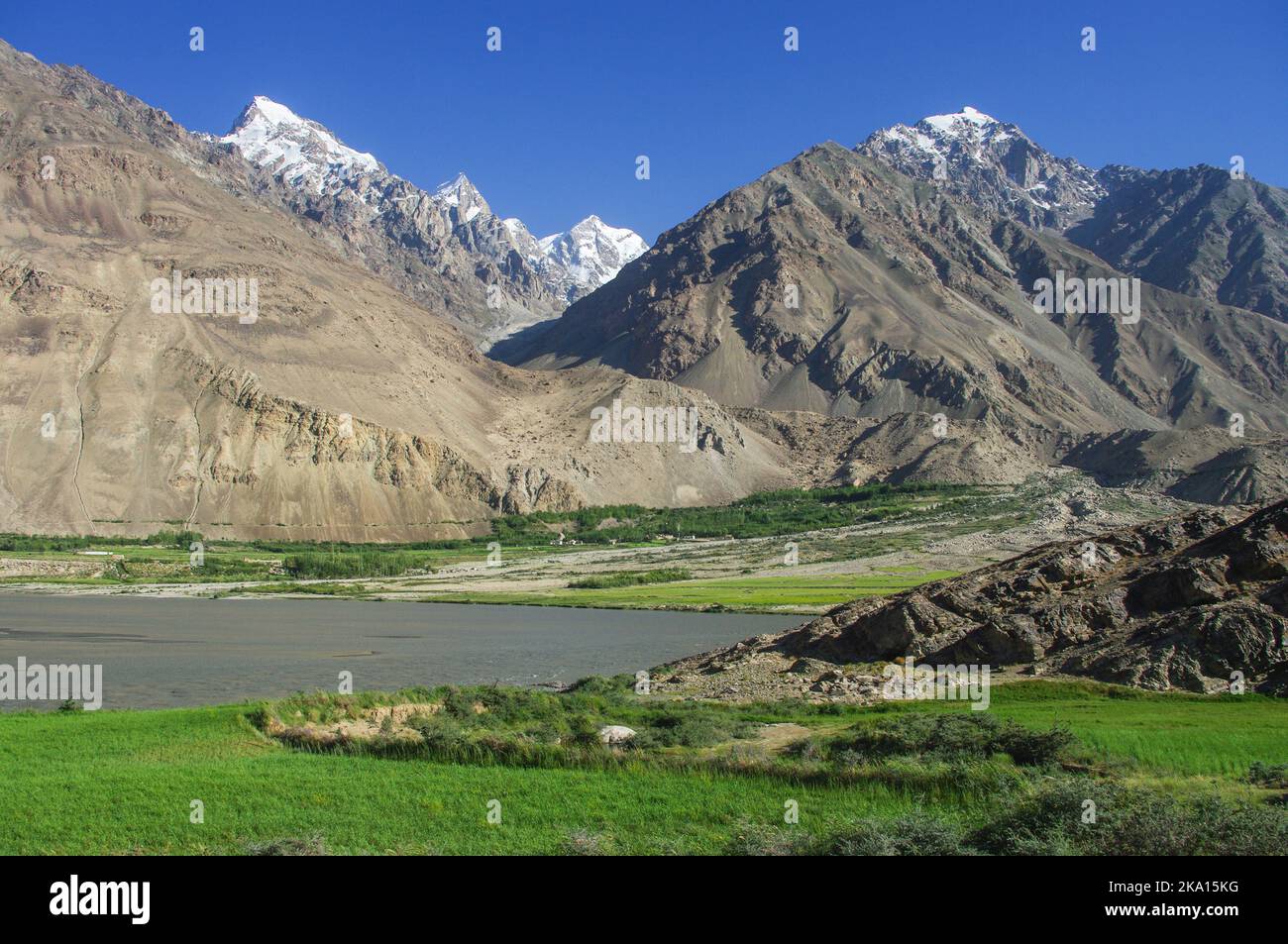 Landscape view of Hindu Kush snow-capped peaks on Afghan side of Panj ...