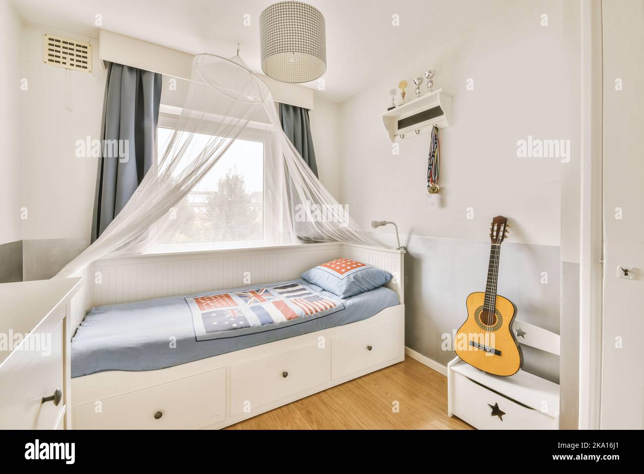 Comfortable bed with blanket and pillows located near closet and ...