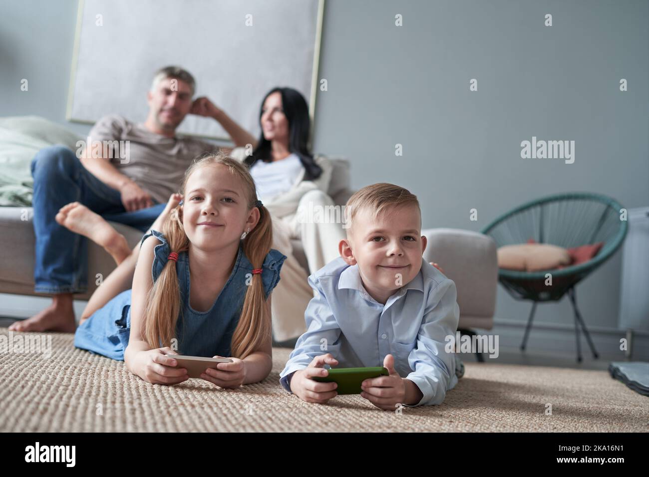 Happy little kids brother and sister use phones at home Stock Photo - Alamy
