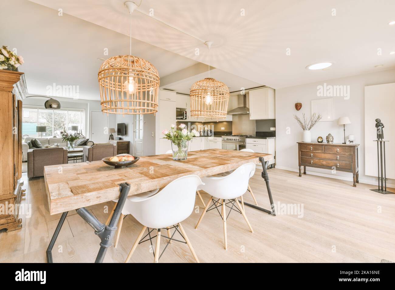 Contemporary open plan kitchen with dining table set and gray sofa in ...