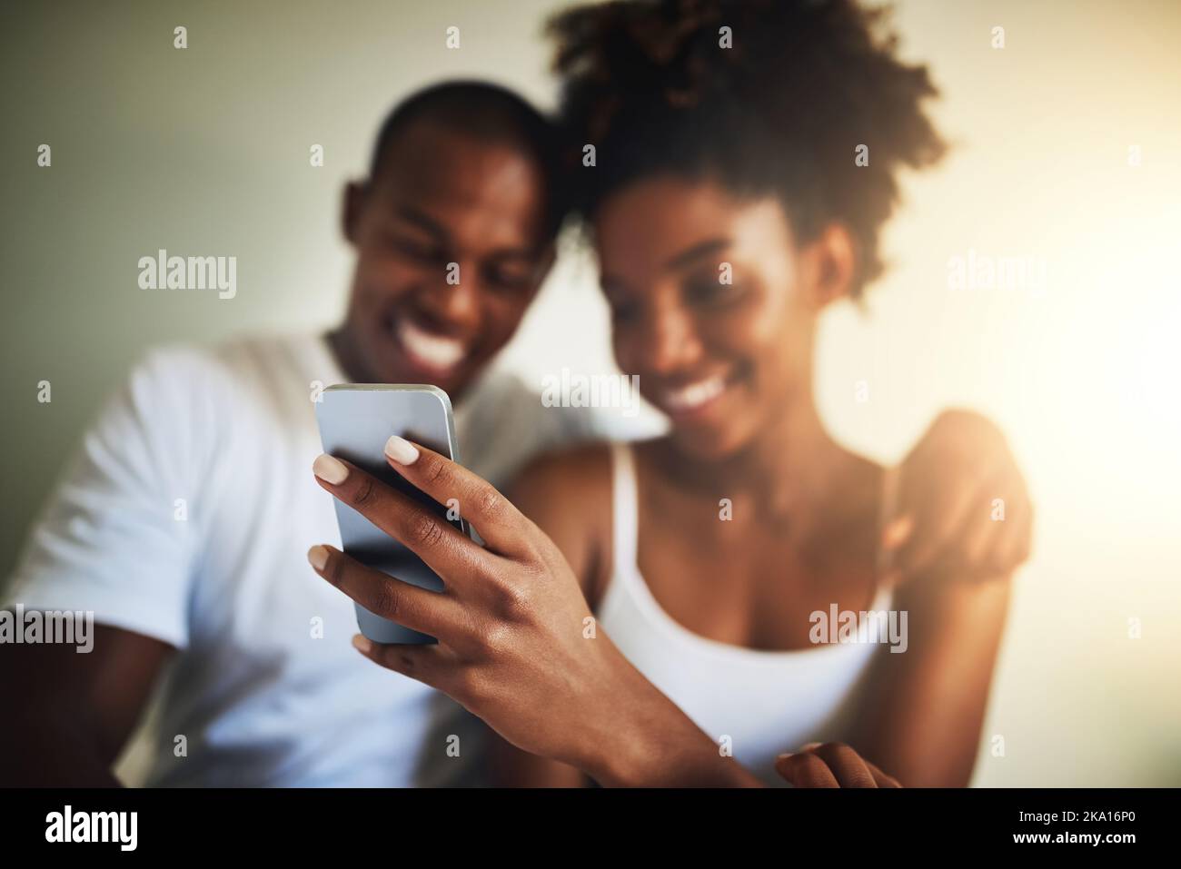 We woke up like this. Portrait of a happy young couple using a mobile ...