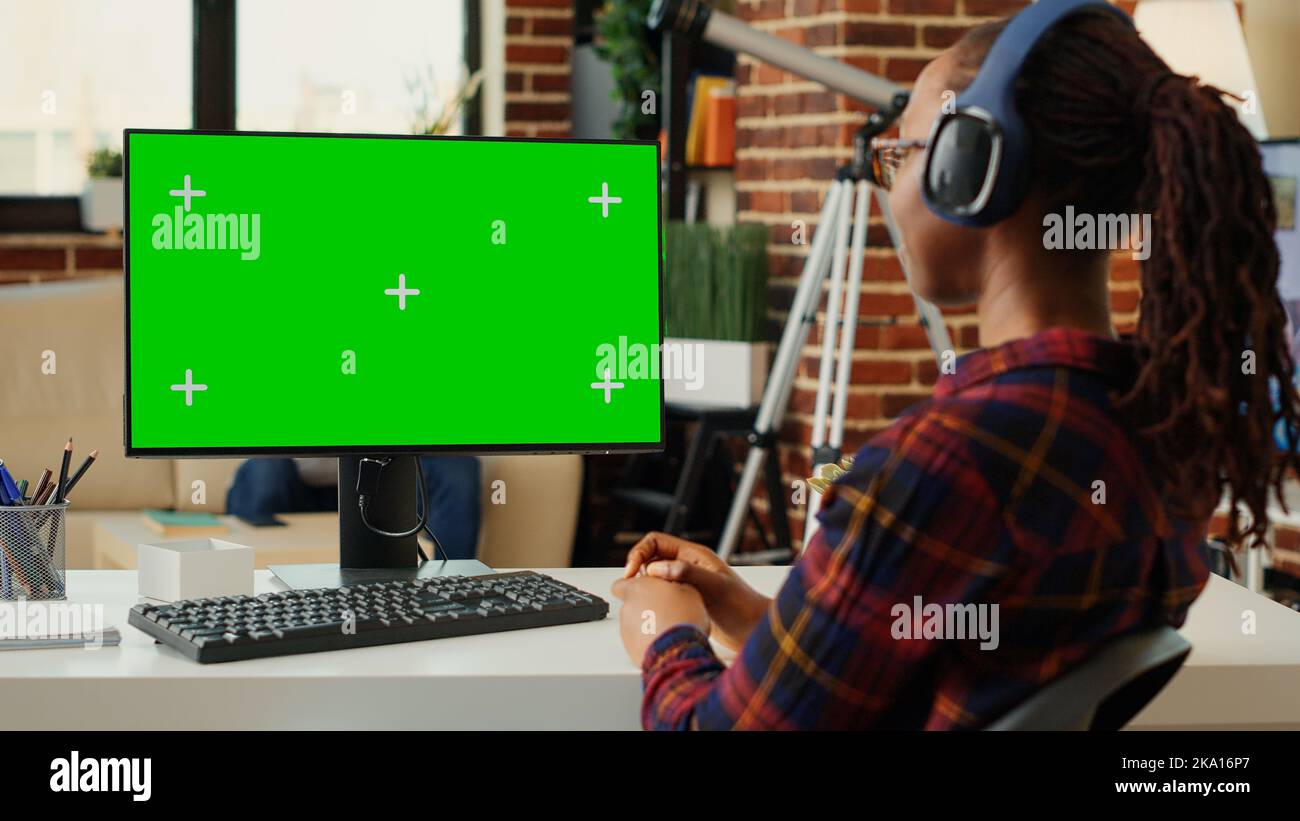 Female manager analyzing greenscreen template on monitor, working with ...
