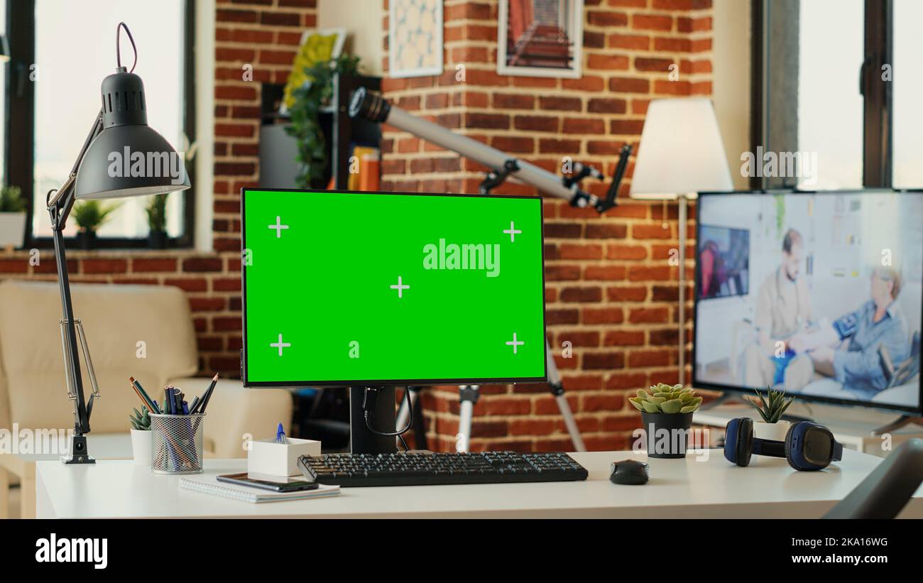 Empty work table with greenscreen template on monitor, isolated mockup background running on ...
