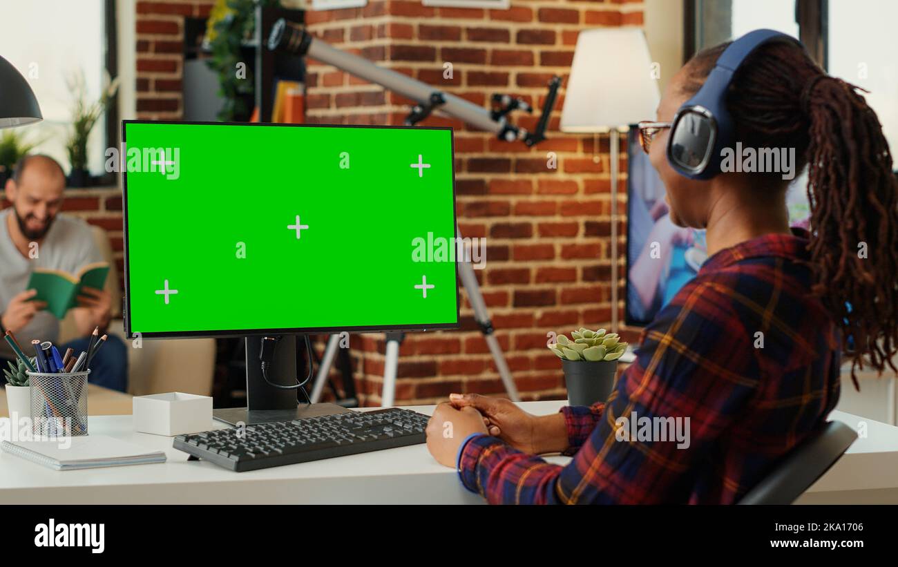 African american woman working with greenscreen and listening to song ...
