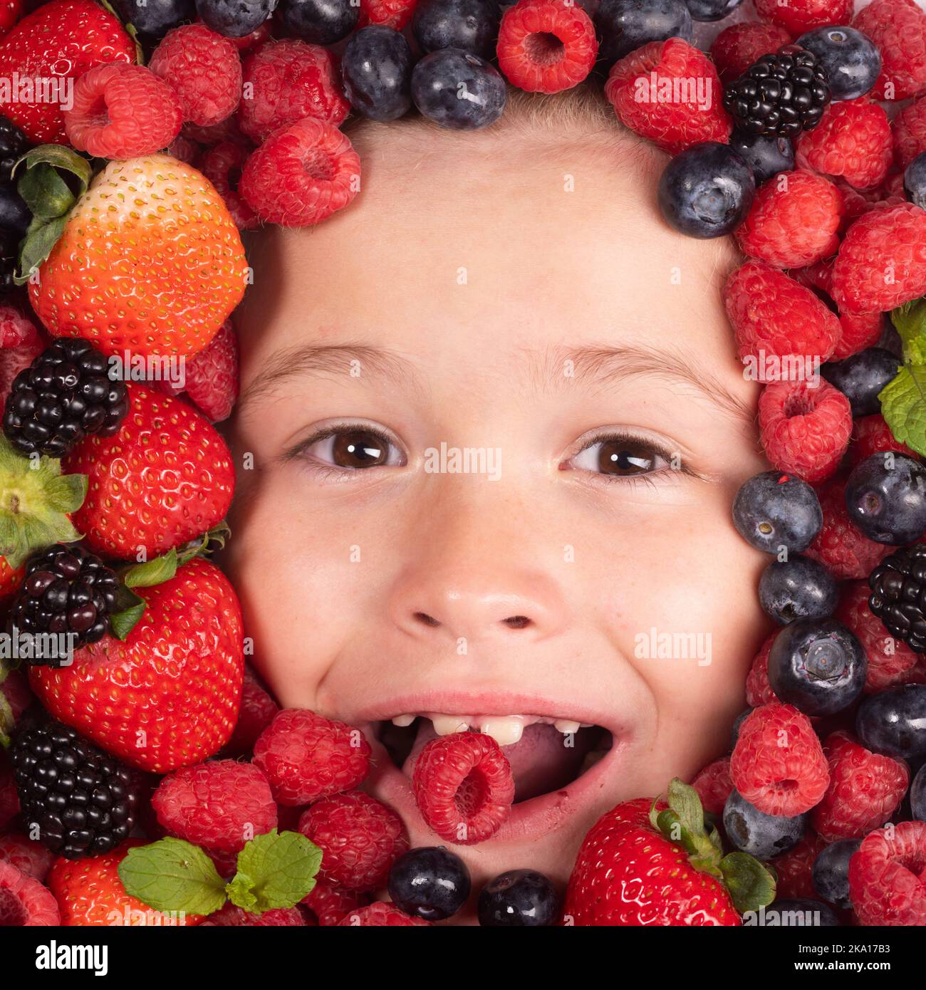 Vitamins from berrie. Kids face with berries mix of strawberry ...