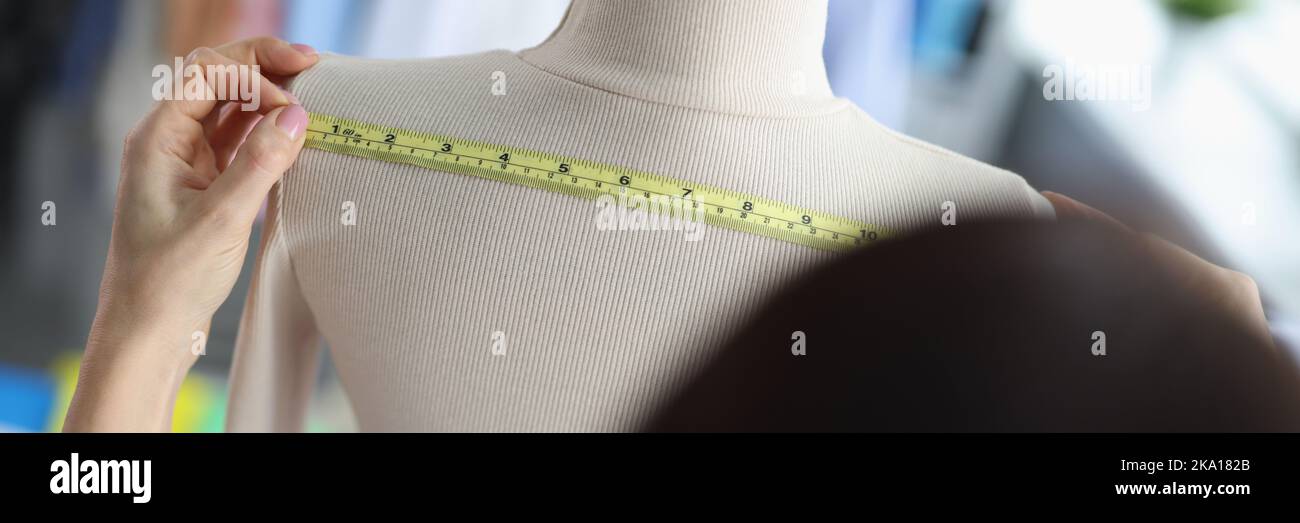 Fashion designer stylist takes measurements of clothes on mannequin ...