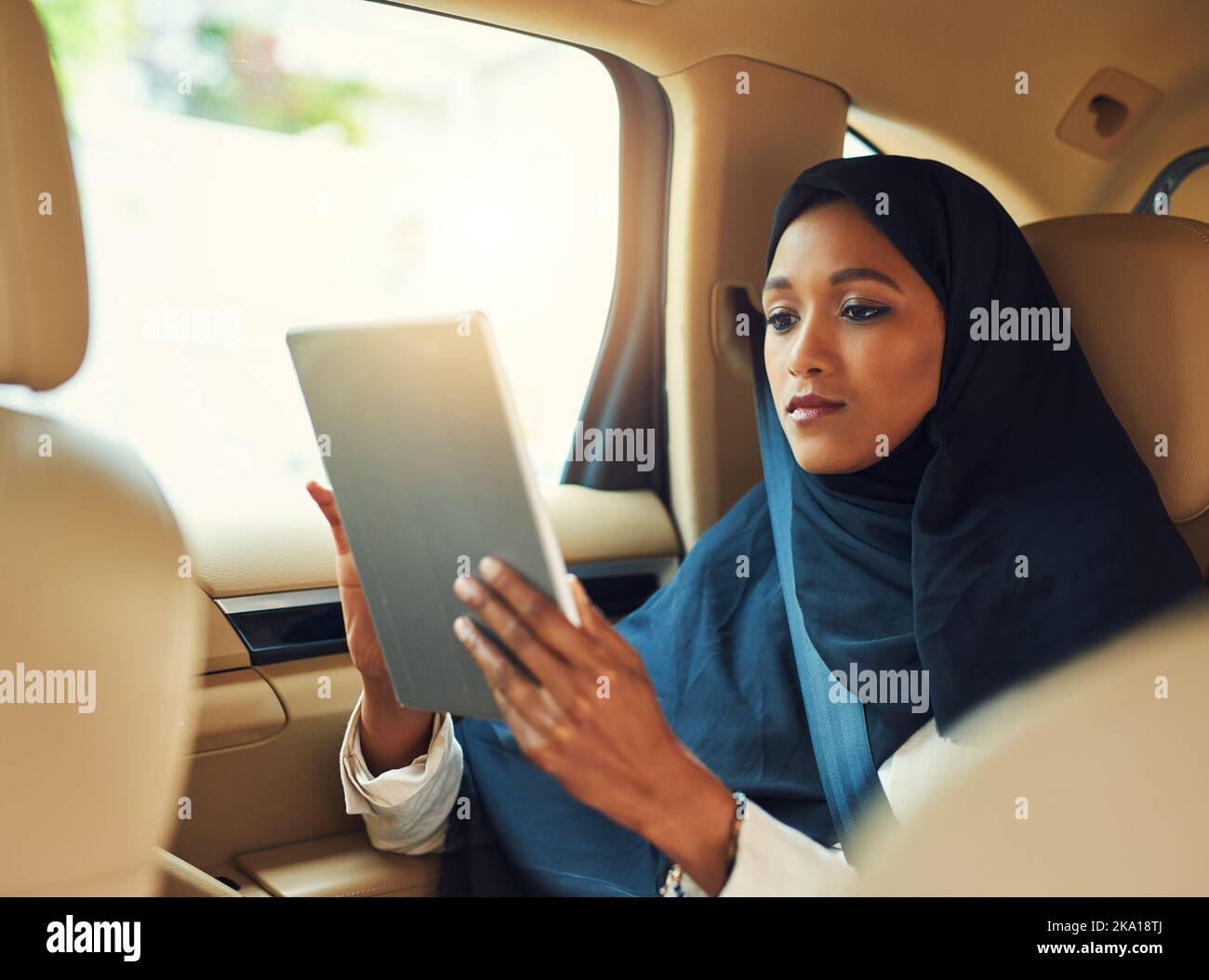 Working before getting to work. a focussed young businesswoman browsing ...