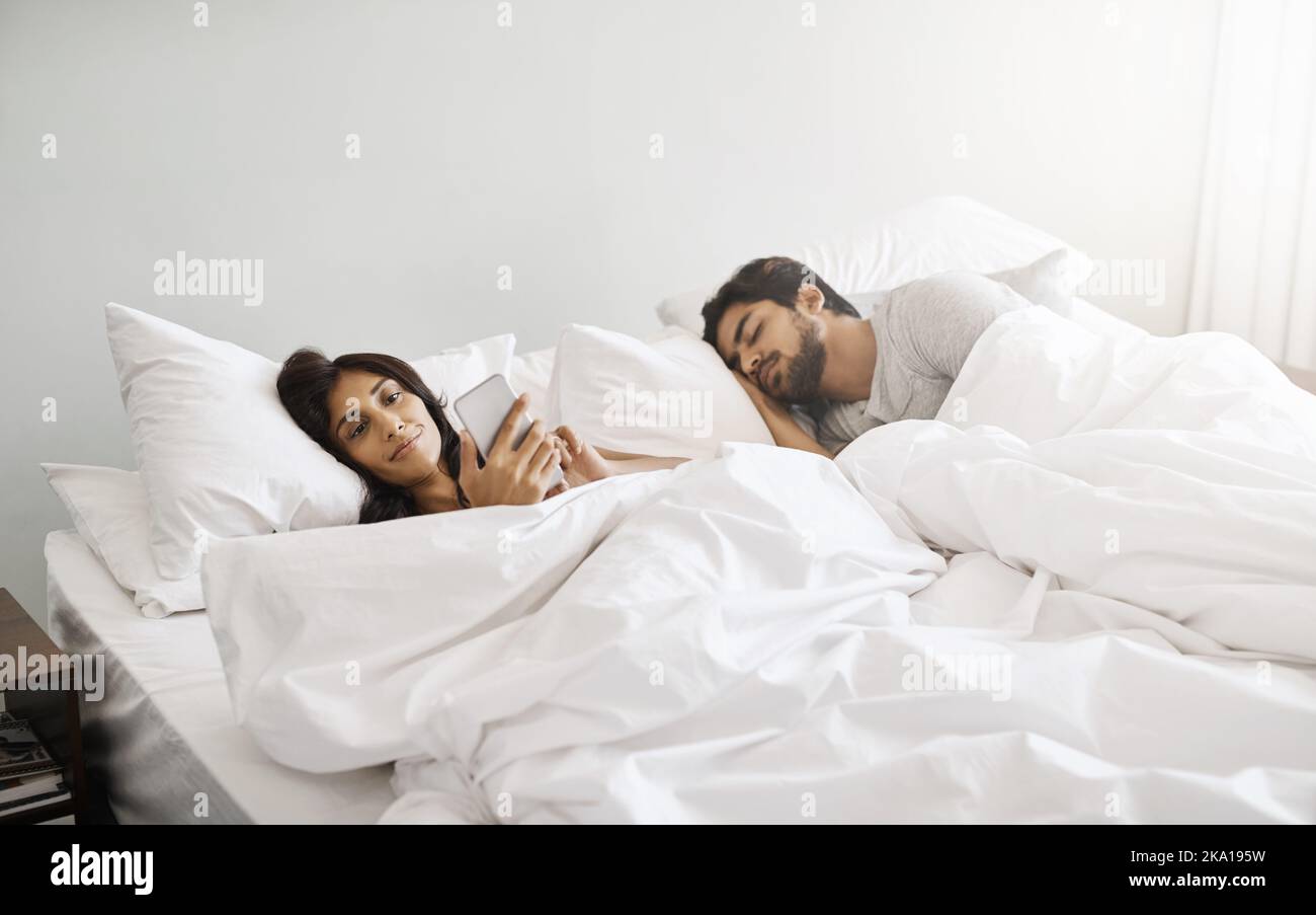 Sending a few early morning texts. an attractive young woman sending ...