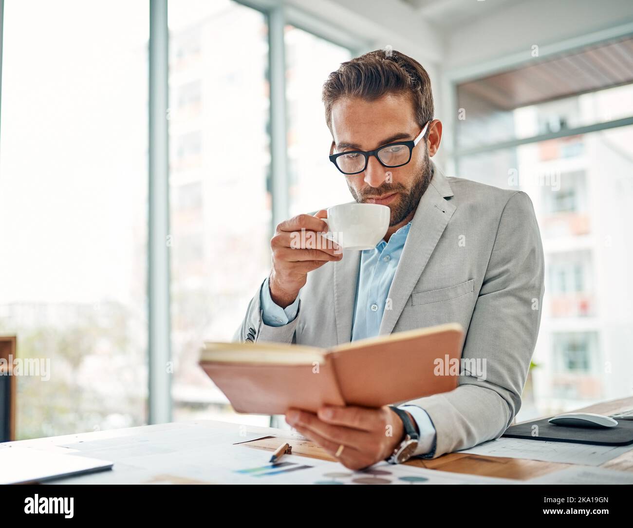 Hes a well-read entrepreneur. a handsome young businessman drinking ...