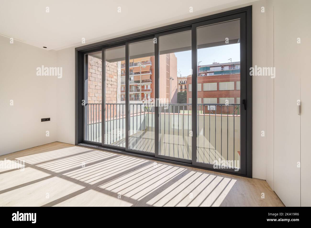 Shadows on the floor from sunlight through big windows. New room with ...