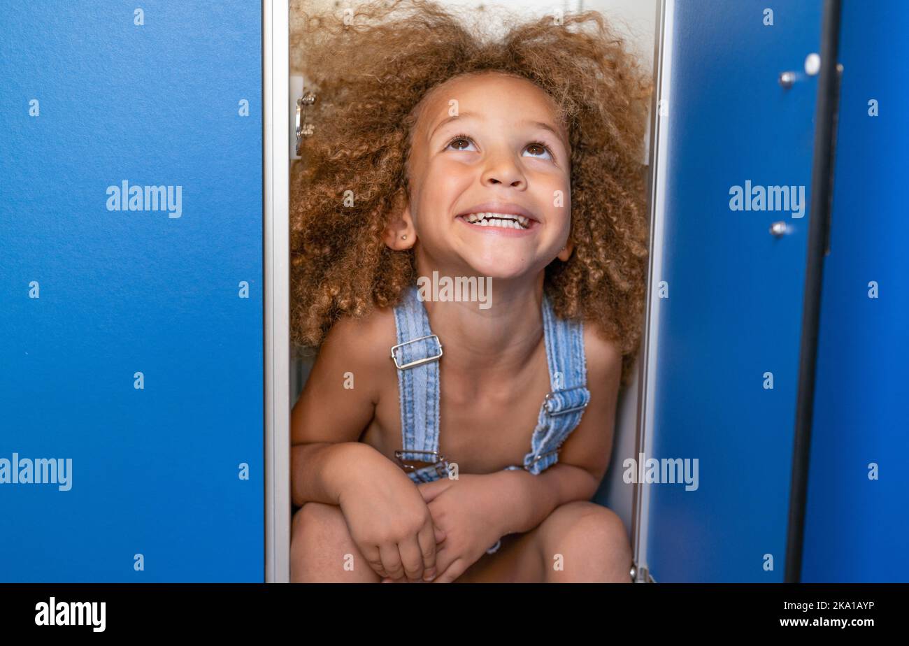 kid girl playing and hiding inside wardrobe Stock Photo - Alamy