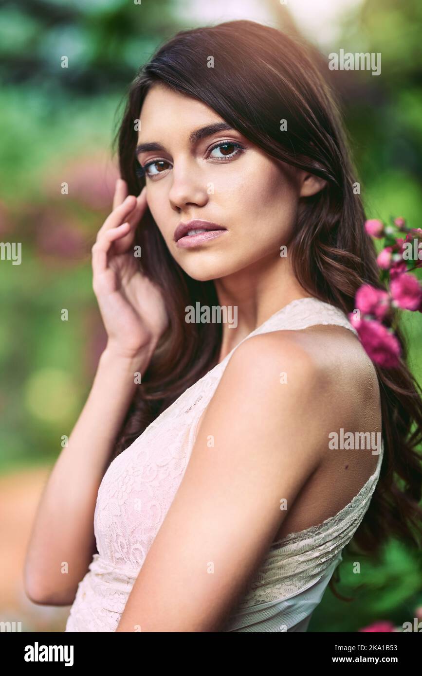 Her beauty is in full bloom. a beautiful young woman posing in nature ...