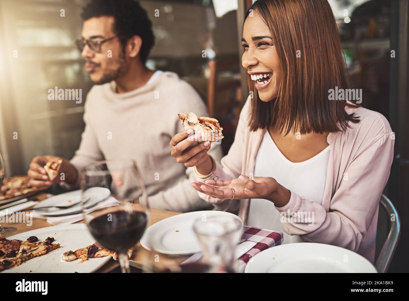This is the best pizza in town. a cheerful young woman and man eating ...