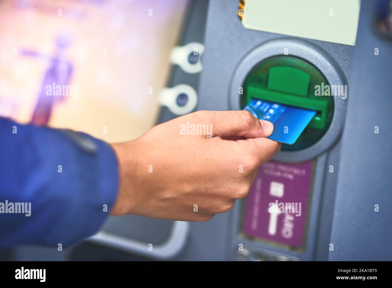 Please insert your card...a woman making a transaction with her bank ...