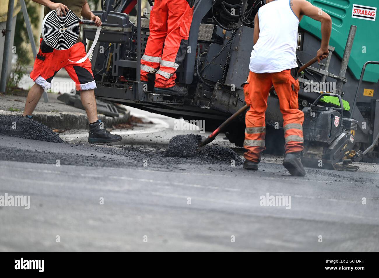 Feet of construction workers paving a road Stock Photo - Alamy