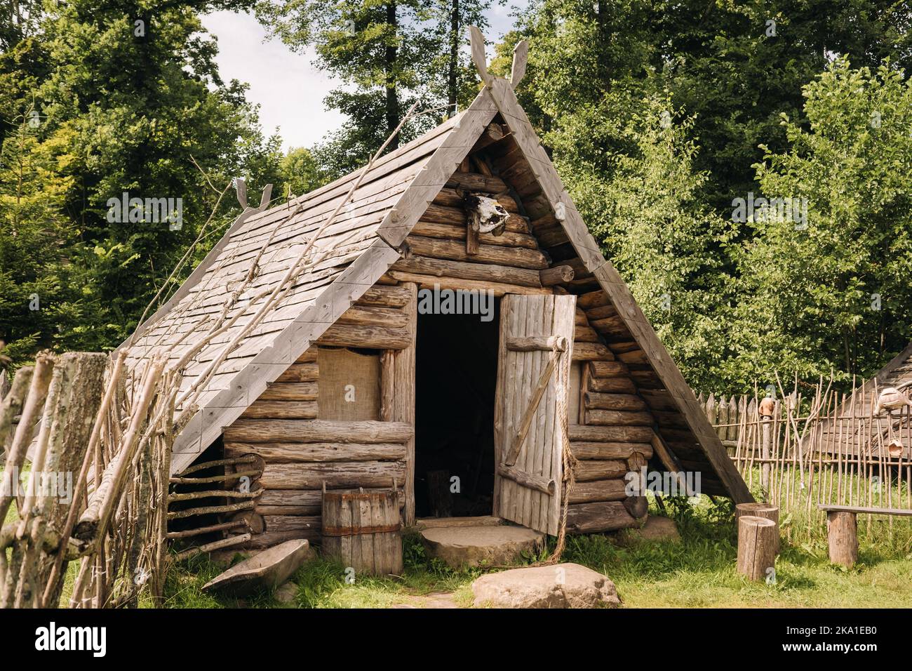 Triangular log houses with wooden roofs behind a fence. Montenegro ...
