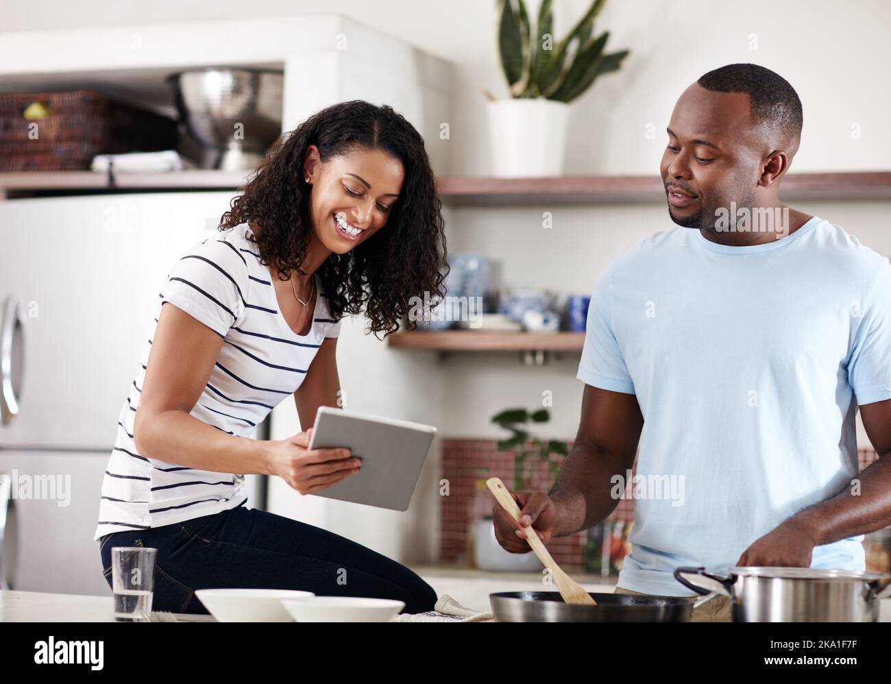 Lets try this recipe. a young married couple using a tablet while ...