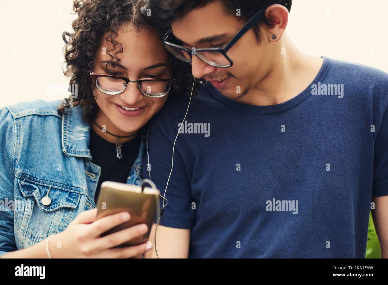 Choosing Our Favourite Tunes Together A Teenage Couple Listening To Music Together Outdoors