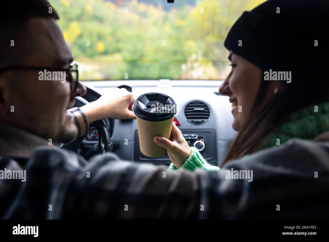 Rear back view from passenger seat of man and lady sitting inside car ...