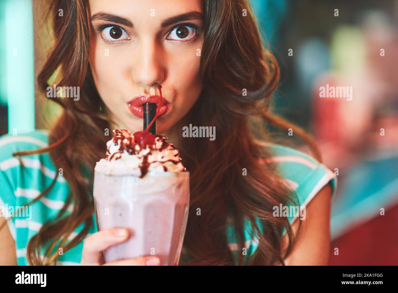 Time for a delicious milkshake at the diner. a beautiful young woman ...