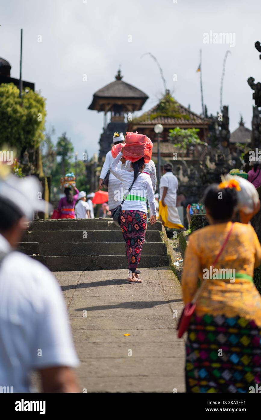 Balinese woman carries offerings to the temple. Back view Stock Photo ...