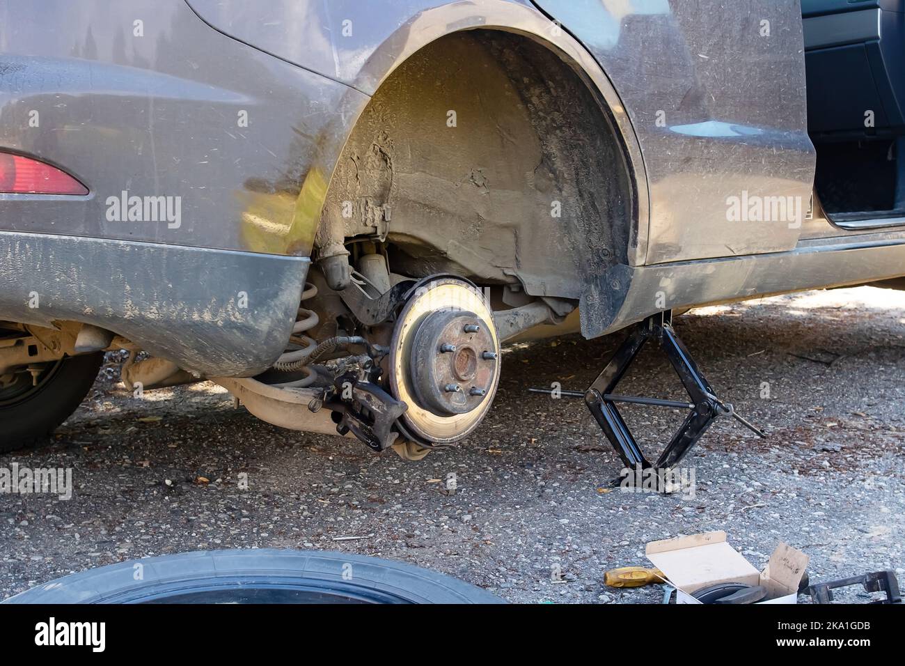 Grey car without wheel and jack close up, repairing Stock Photo - Alamy