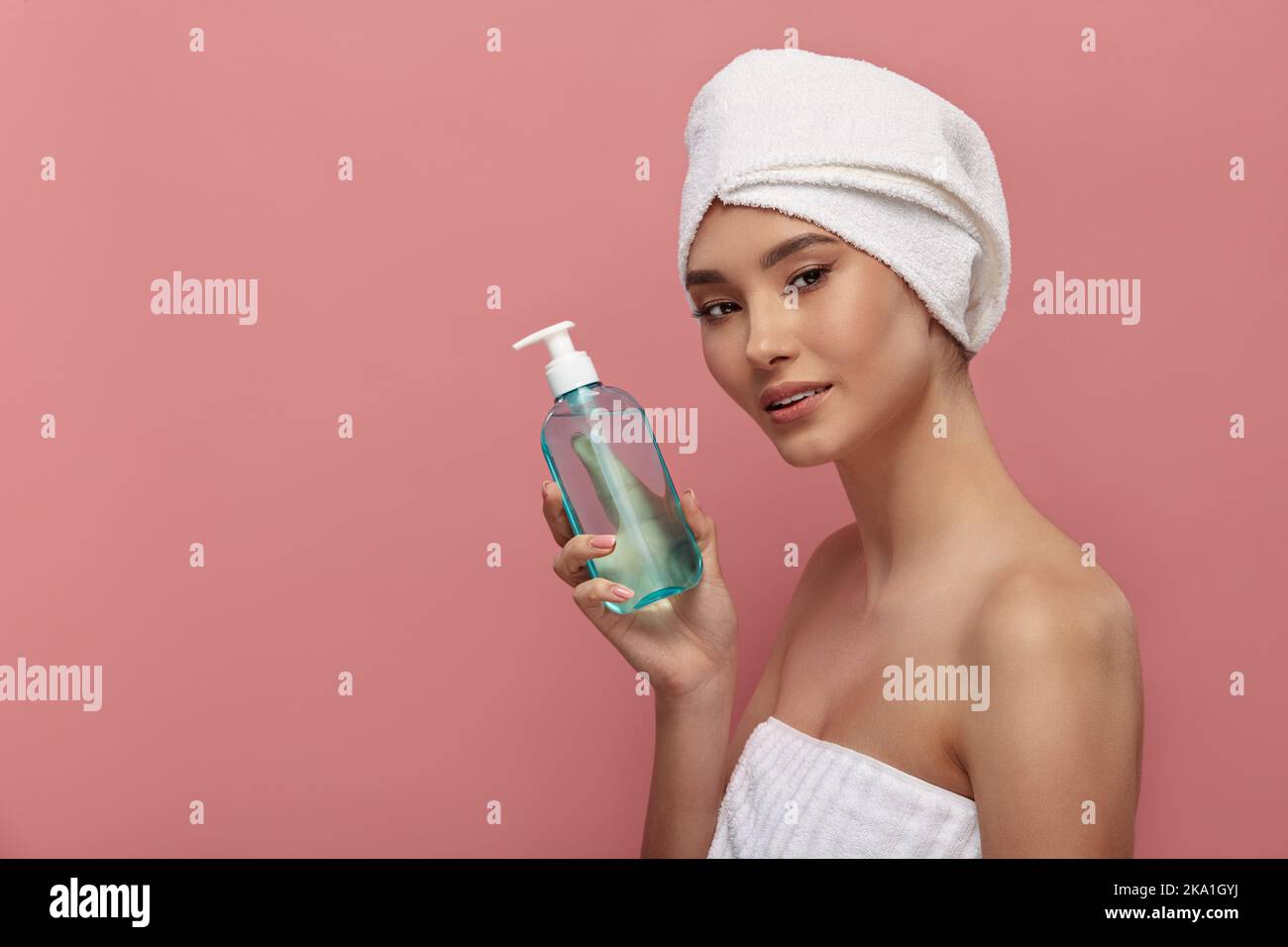 Attractive woman holds plastic bottle mockup with dispenser Stock Photo ...