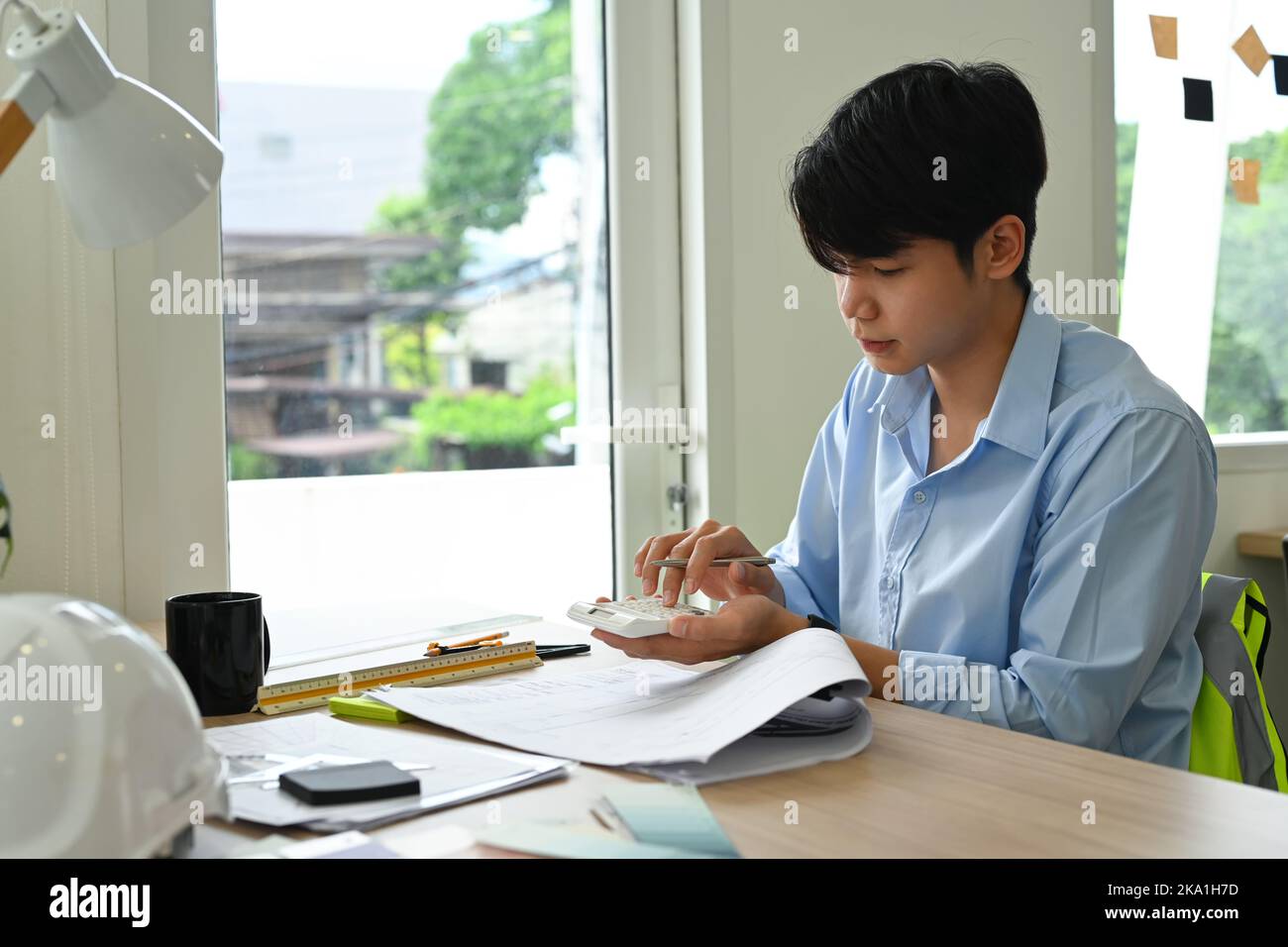 Handsome Architects man looking at blueprint, working on construction ...