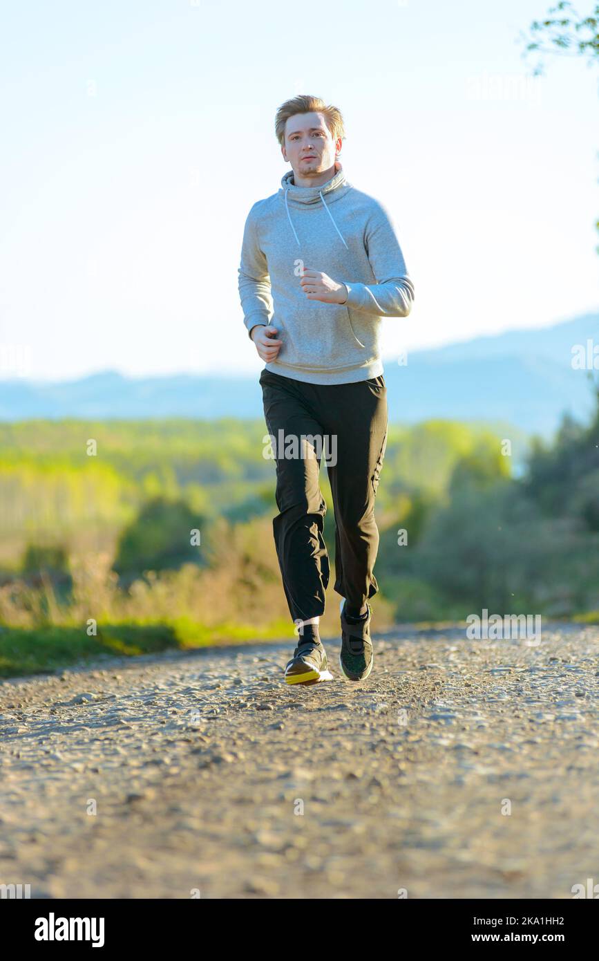 Running man jogging in rural nature at beautiful summer day. Sport ...