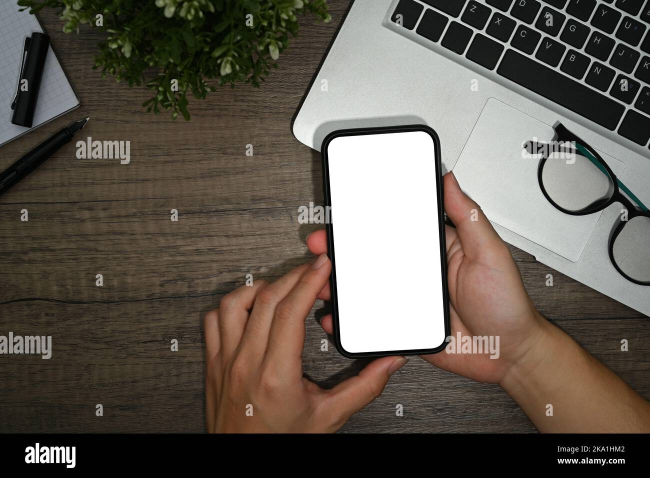 From above view of man hand holding smart phone with white empty screen ...